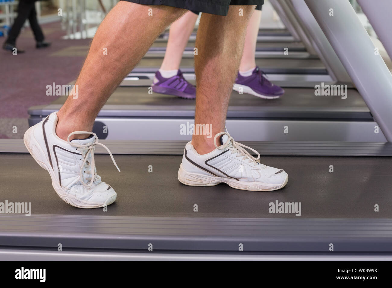 Man and woman walking on treadmills at the gym Stock Photo - Alamy