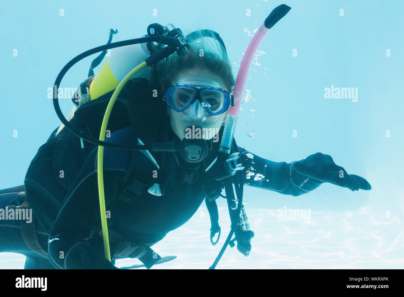 Woman on scuba training submerged in swimming pool on her holidays ...
