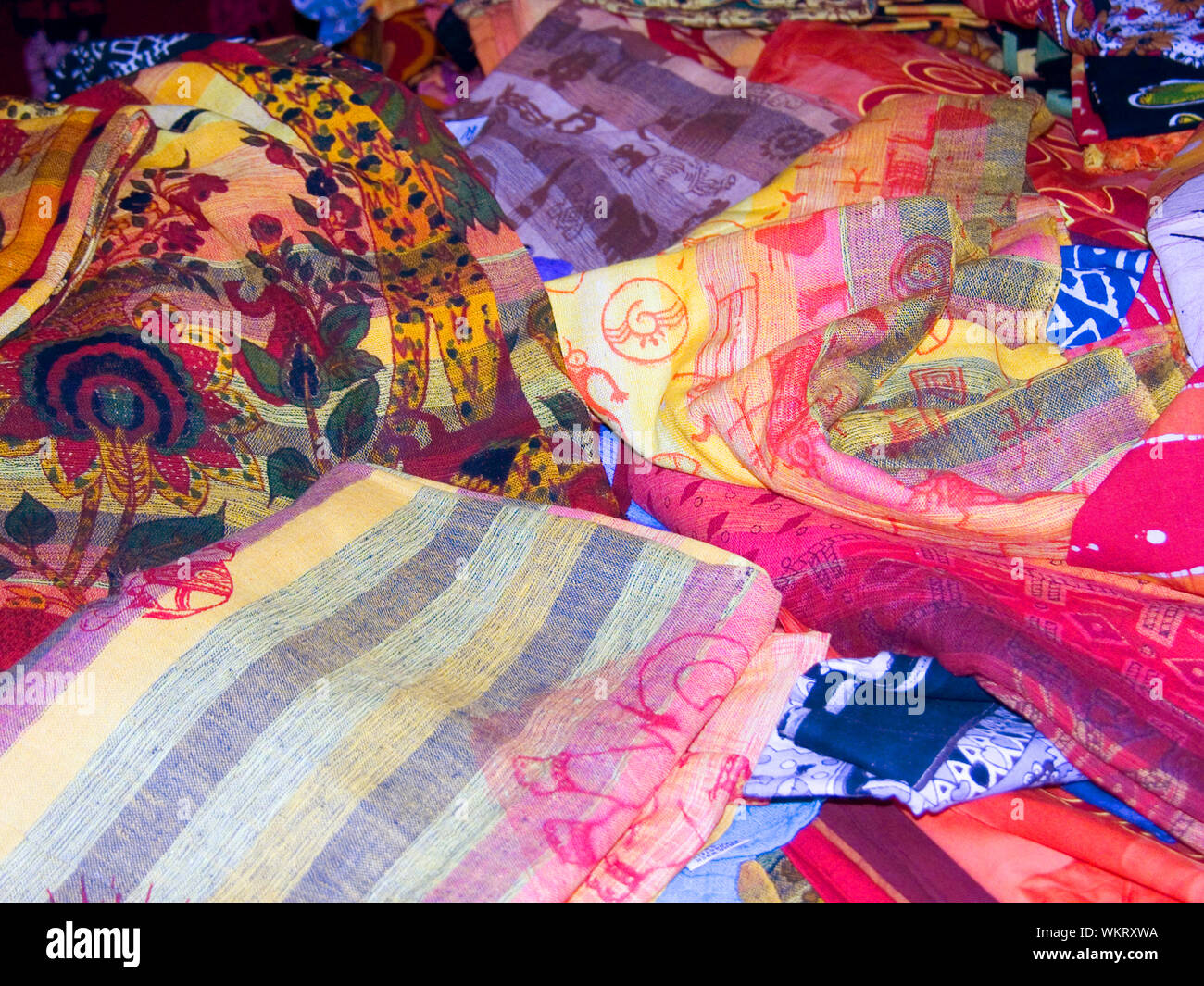 Brightly coloured fabrics on a street market stall, Rue Gambetta ...