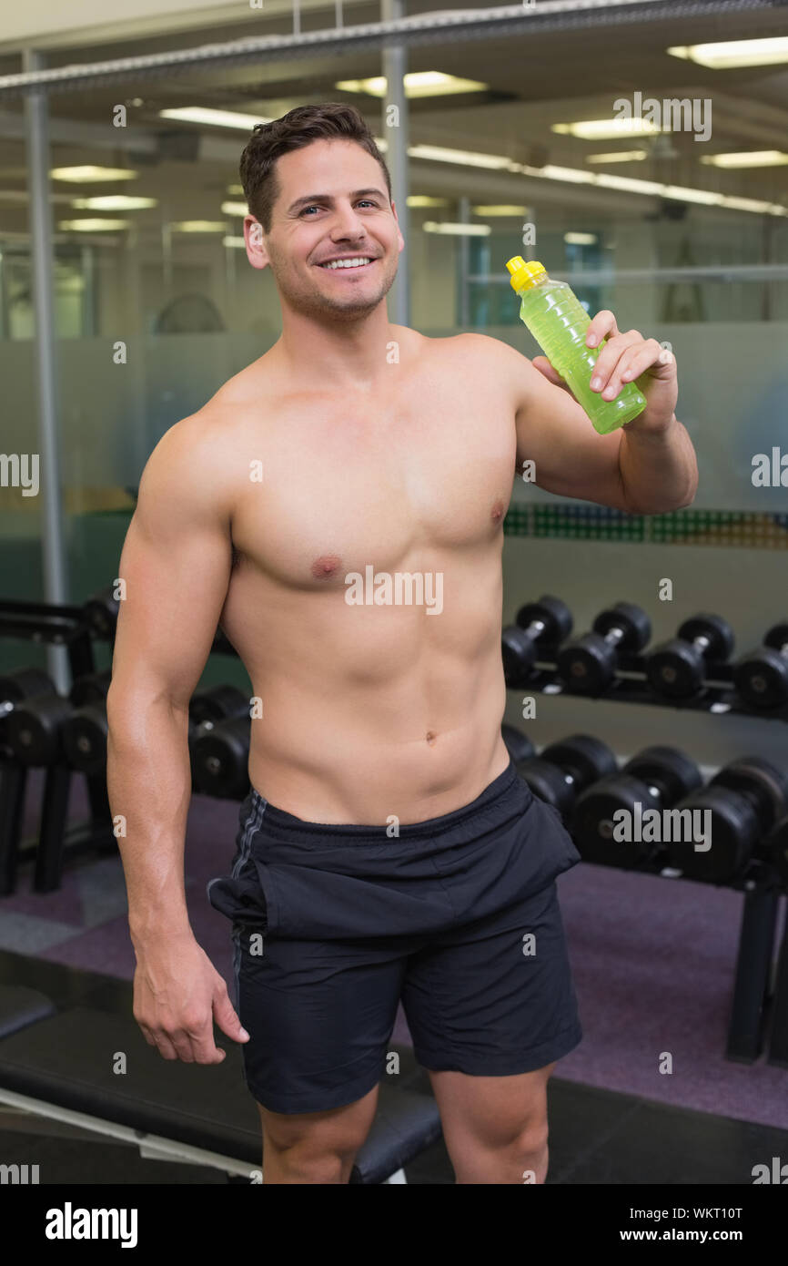 Shirtless bodybuilder drinking sports drink smiling at camera at the ...