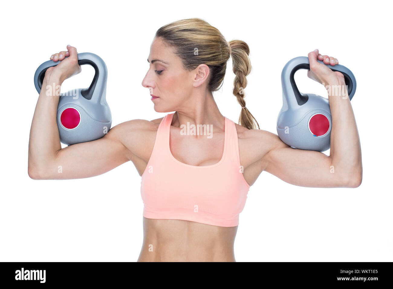 Strong female crossfitter lifting kettlebells on white background Stock ...