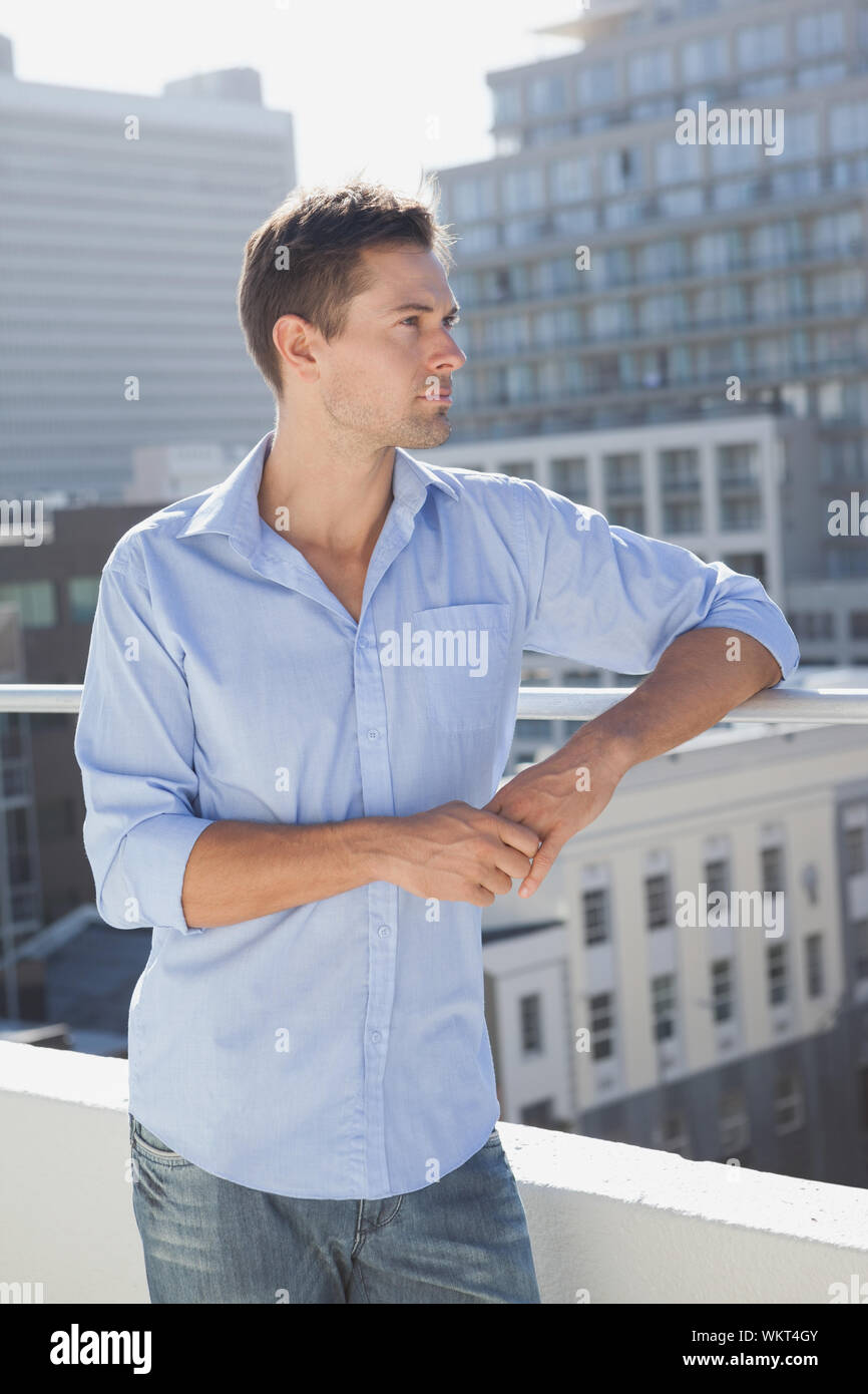 Handsome man looking over on his balcony on a sunny day Stock Photo - Alamy