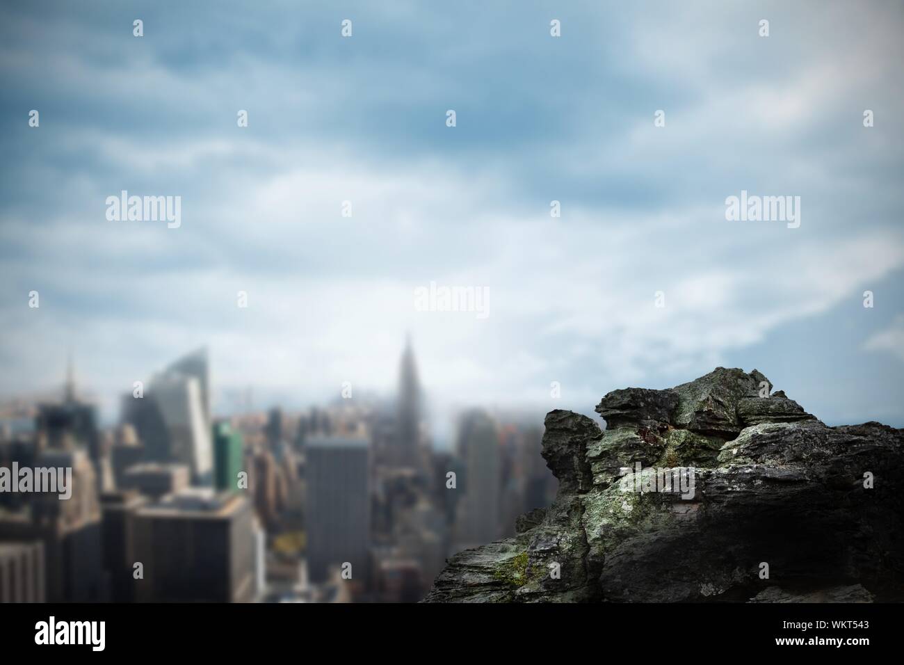 Digitally generated large rock overlooking big city Stock Photo - Alamy