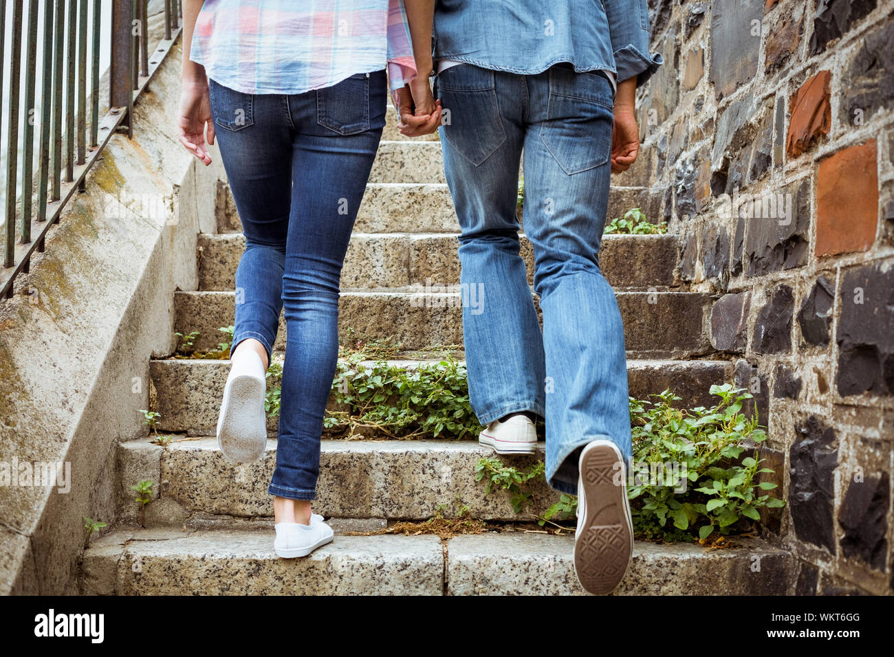 Hip young couple walking up steps on a sunny day in the city Stock ...