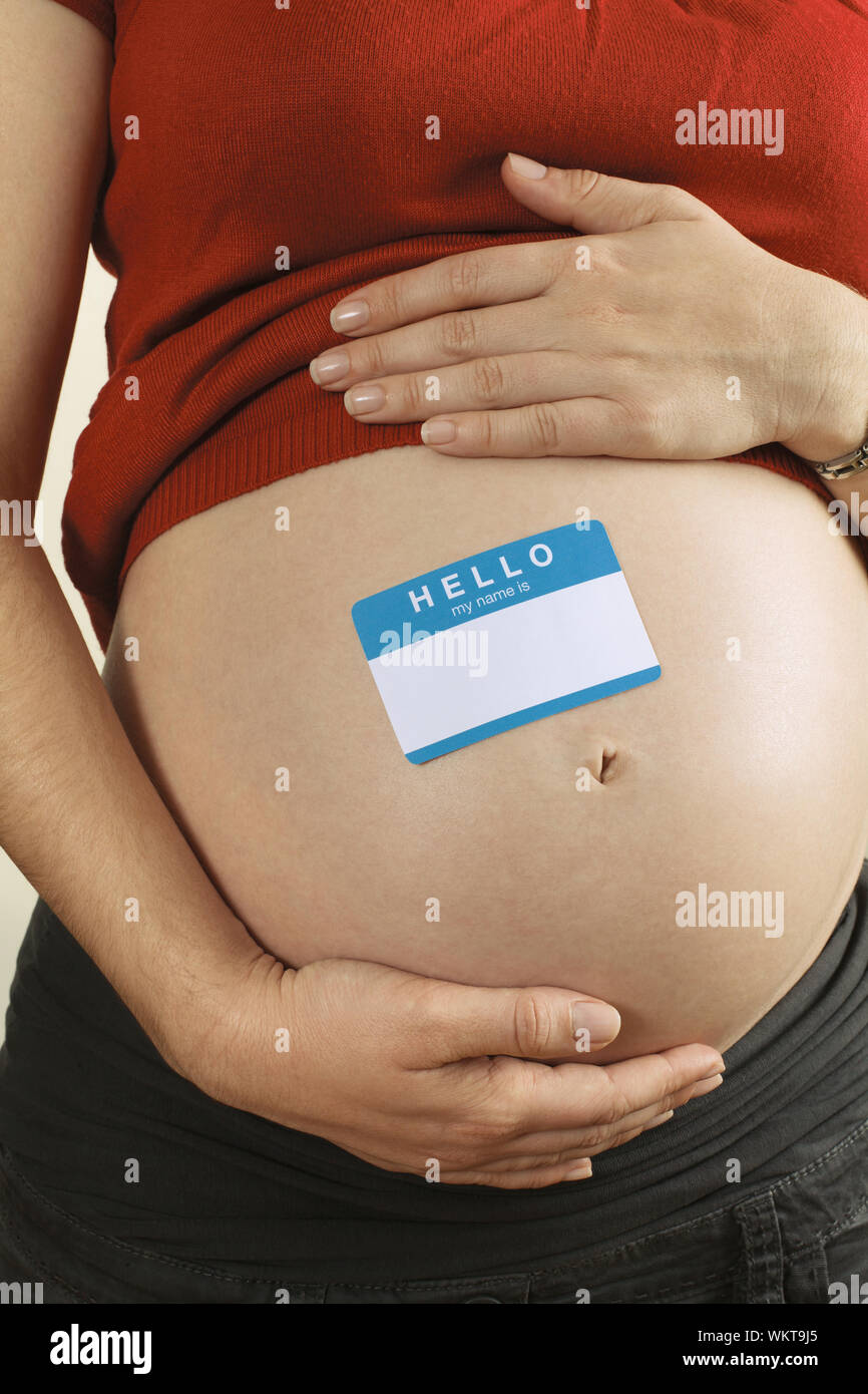Photo of a pregnant female with a Hello My Name Is sticker on her belly ...