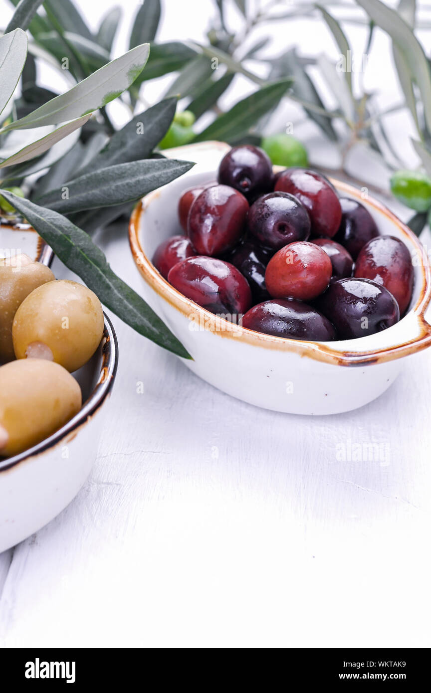 Traditional appetizers, green and red olives from Greek cuisine. White ...