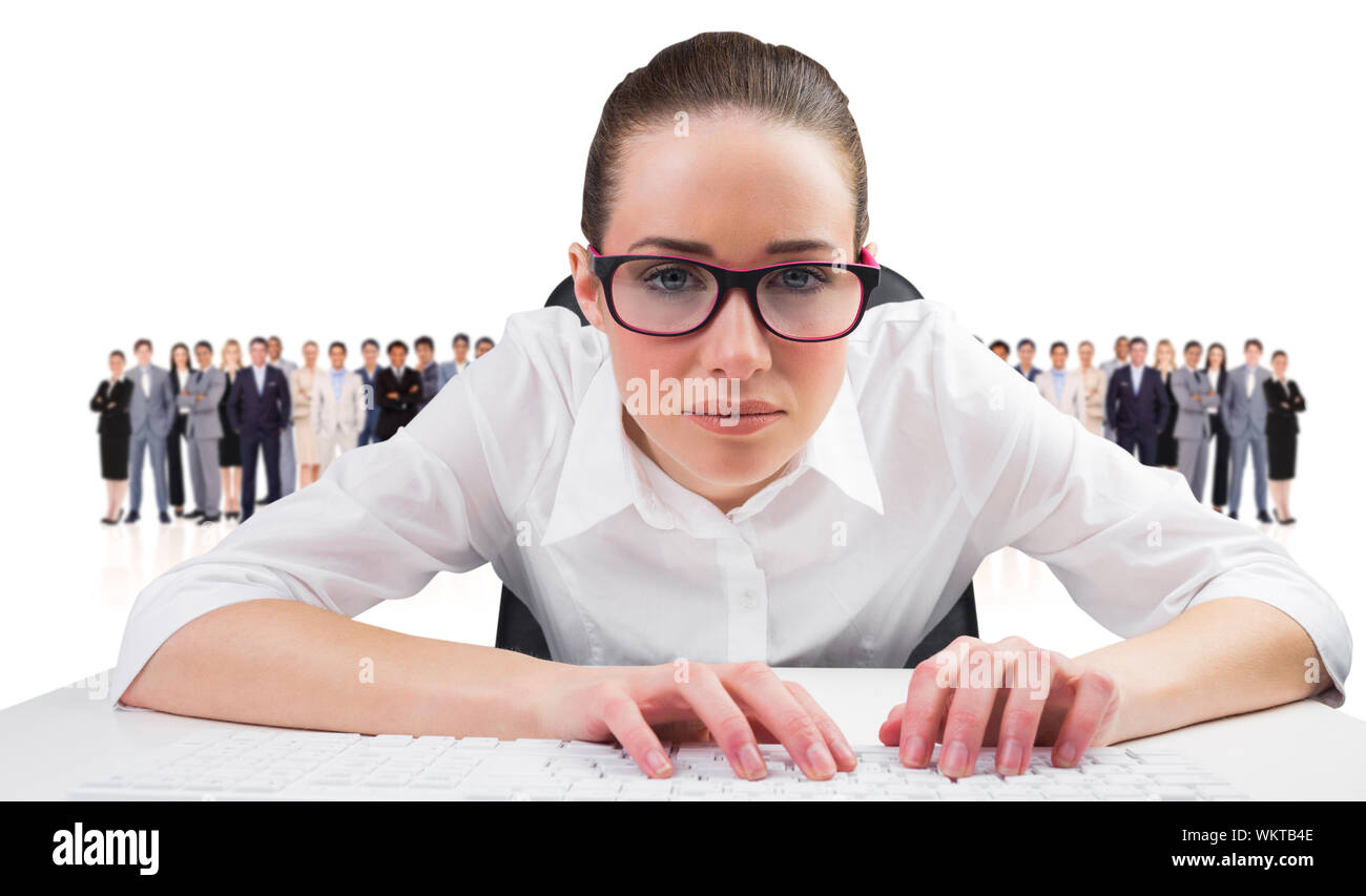 Composite image of businesswoman typing on a keyboard against group of ...