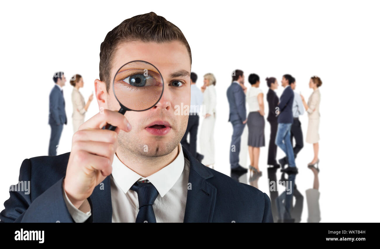 Composite image of businessman looking through magnifying glass against ...