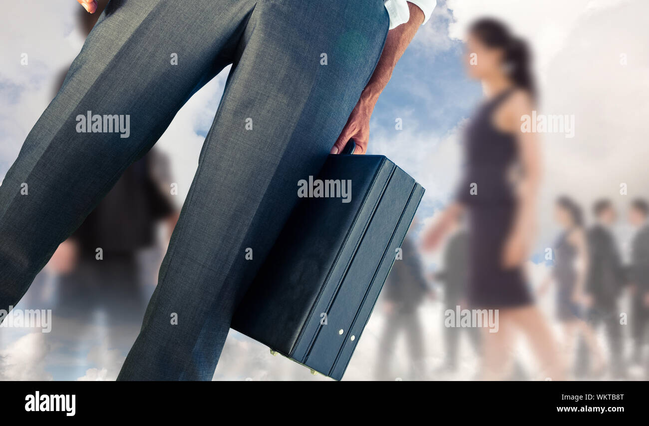Businessman holding briefcase against blue sky with white clouds and ...