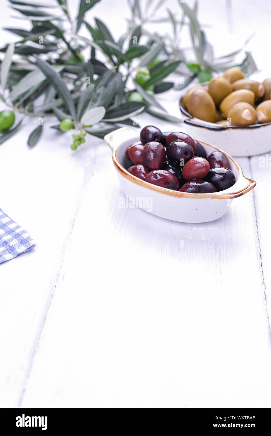 Traditional appetizers, green and red olives from Greek cuisine. White ...