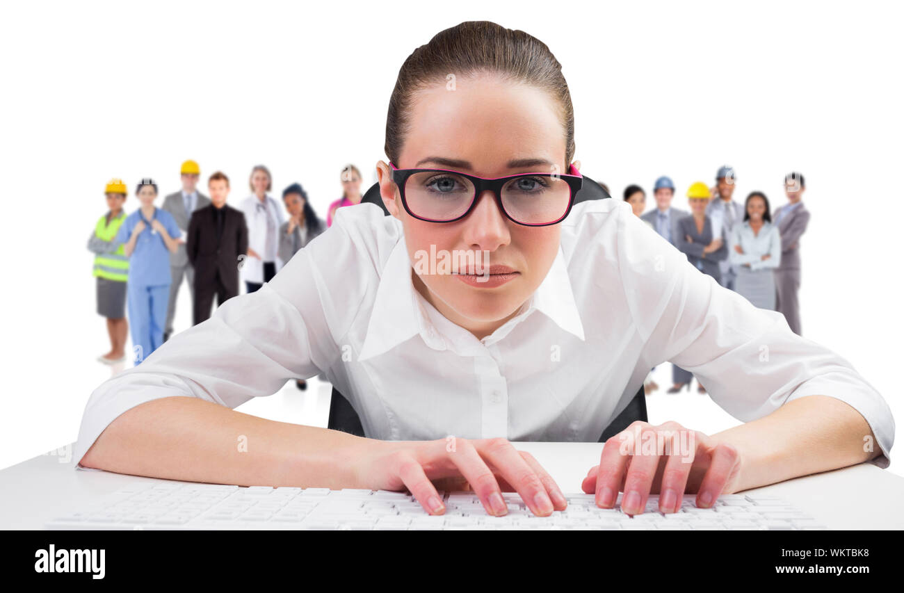 Composite image of businesswoman typing on a keyboard against group of ...