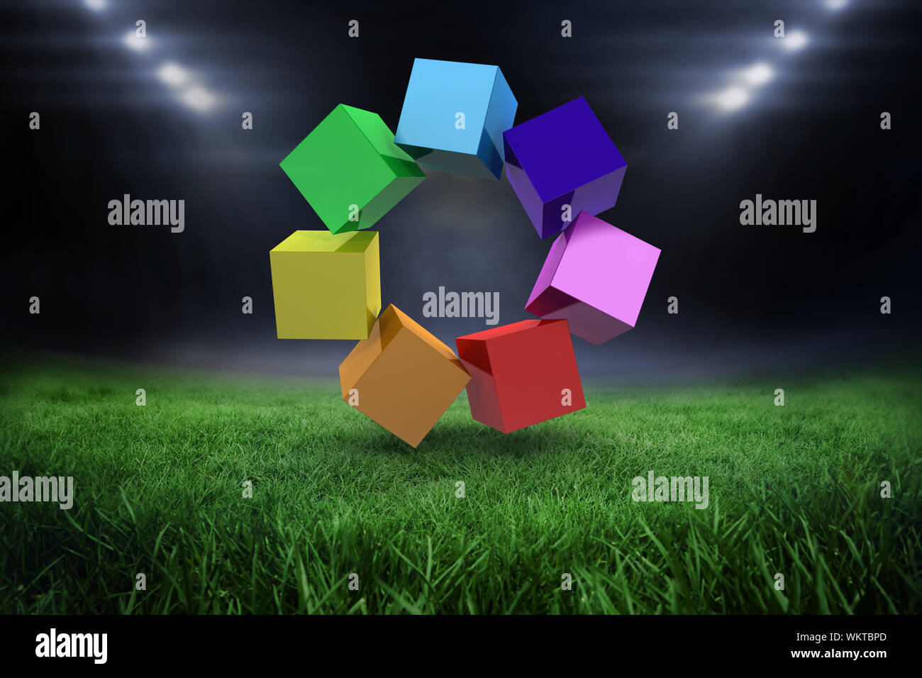 3d colourful cubes in a circle against football pitch with bright ...