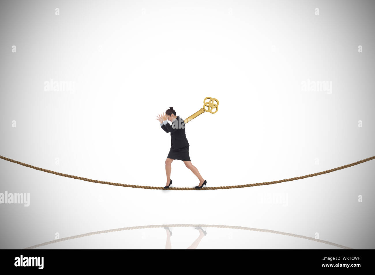 Wound up businesswoman gesturing on tightrope against white background ...