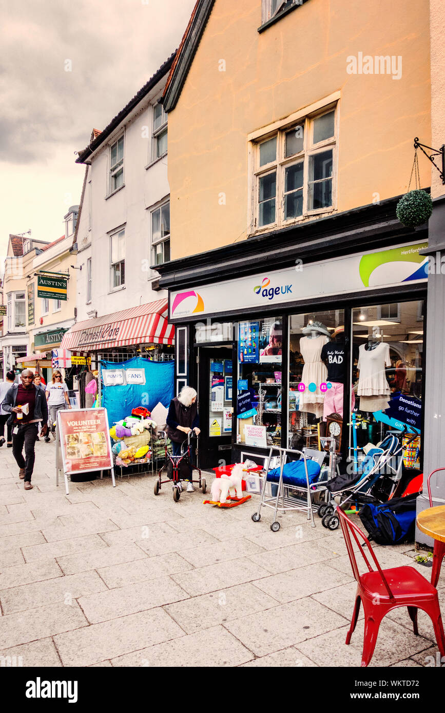 Old lady coming out of the age concern charity shop hi-res stock ...