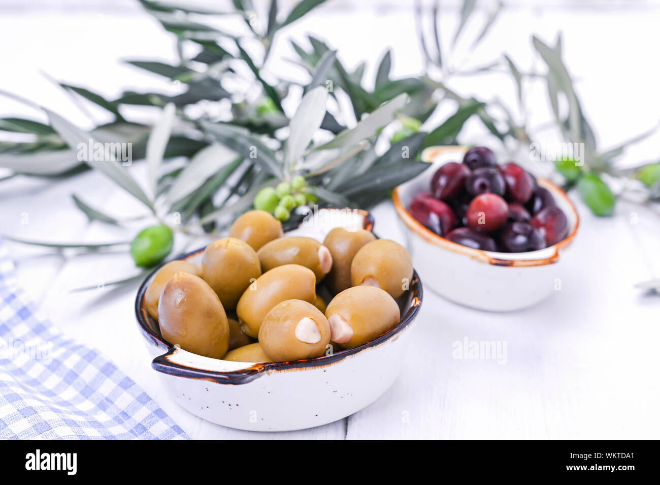 Traditional appetizers, green and red olives from Greek cuisine. White ...