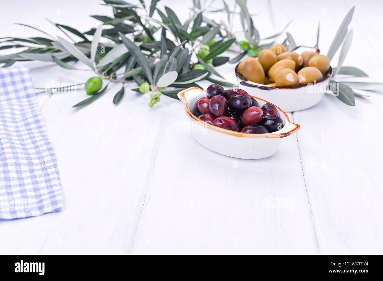 Traditional appetizers, green and red olives from Greek cuisine. White ...