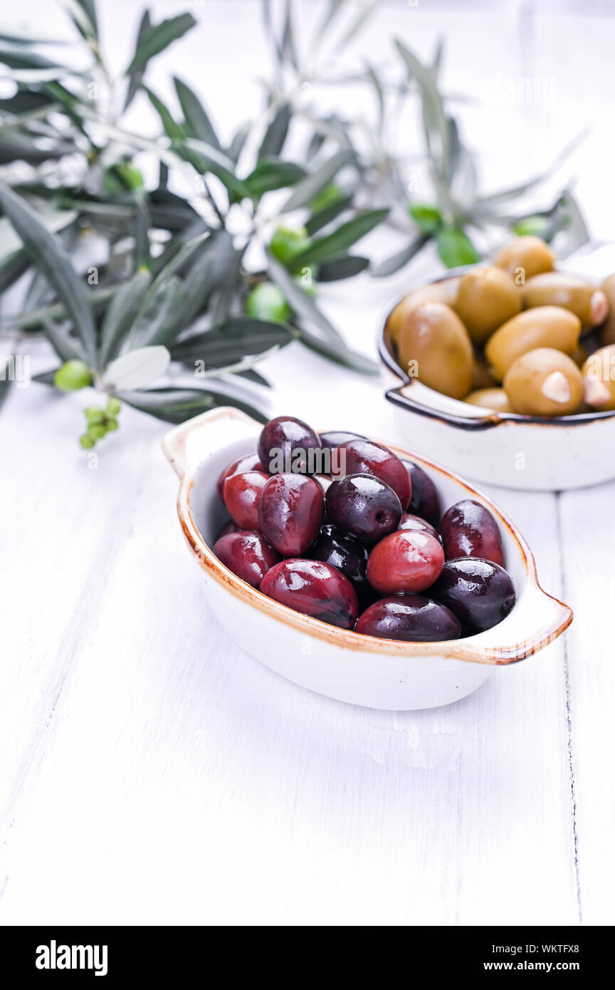 Traditional appetizers, green and red olives from Greek cuisine. White ...