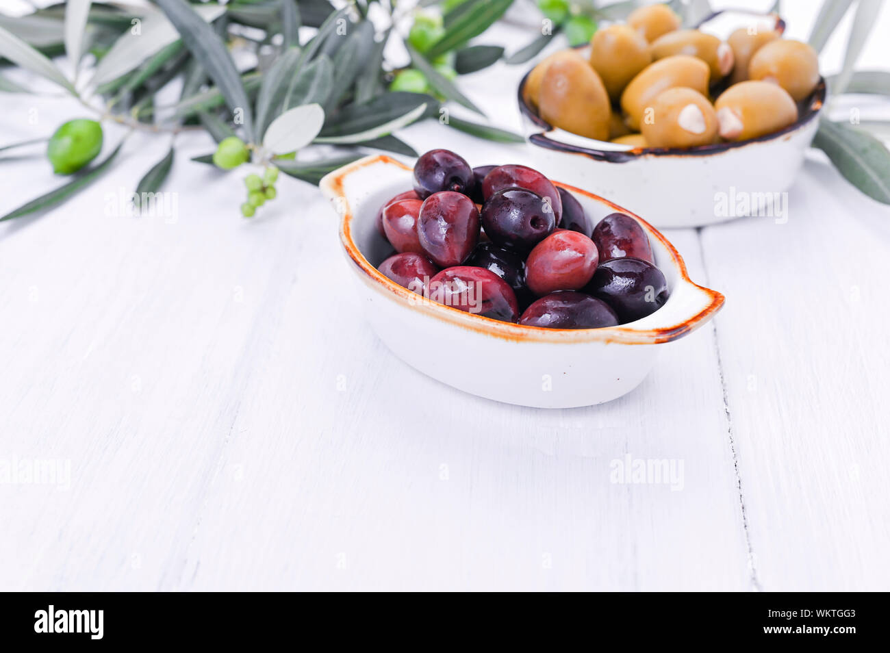 Traditional appetizers, green and red olives from Greek cuisine. White ...