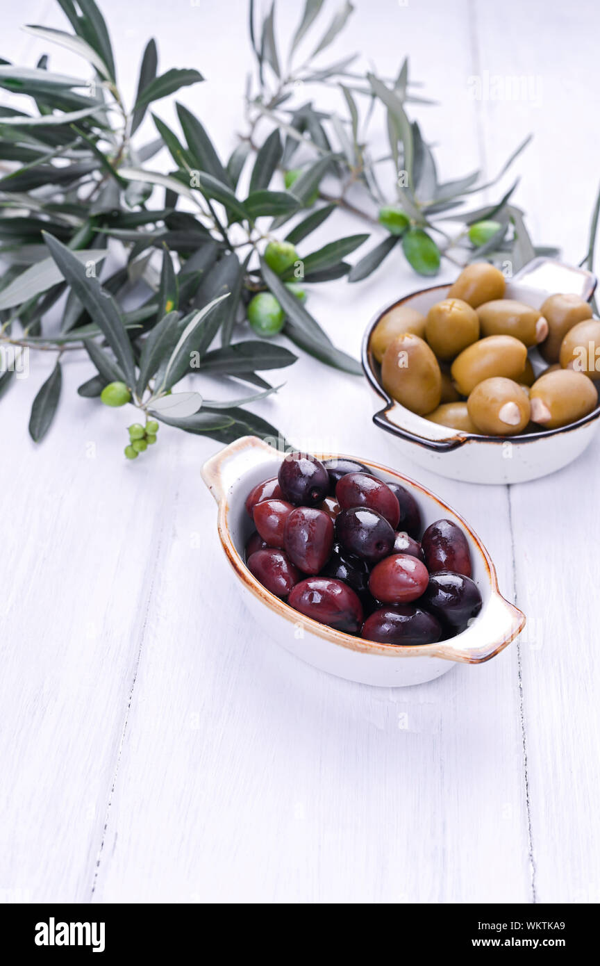 Traditional appetizers, green and red olives from Greek cuisine. White ...