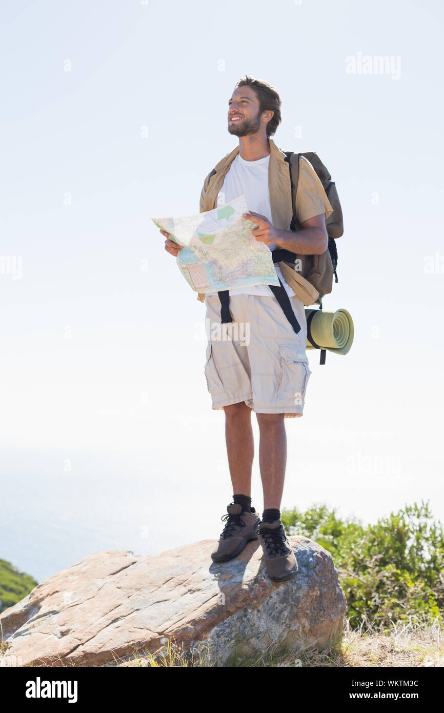 Handsome hiker holding map at mountain summit on a sunny day Stock ...