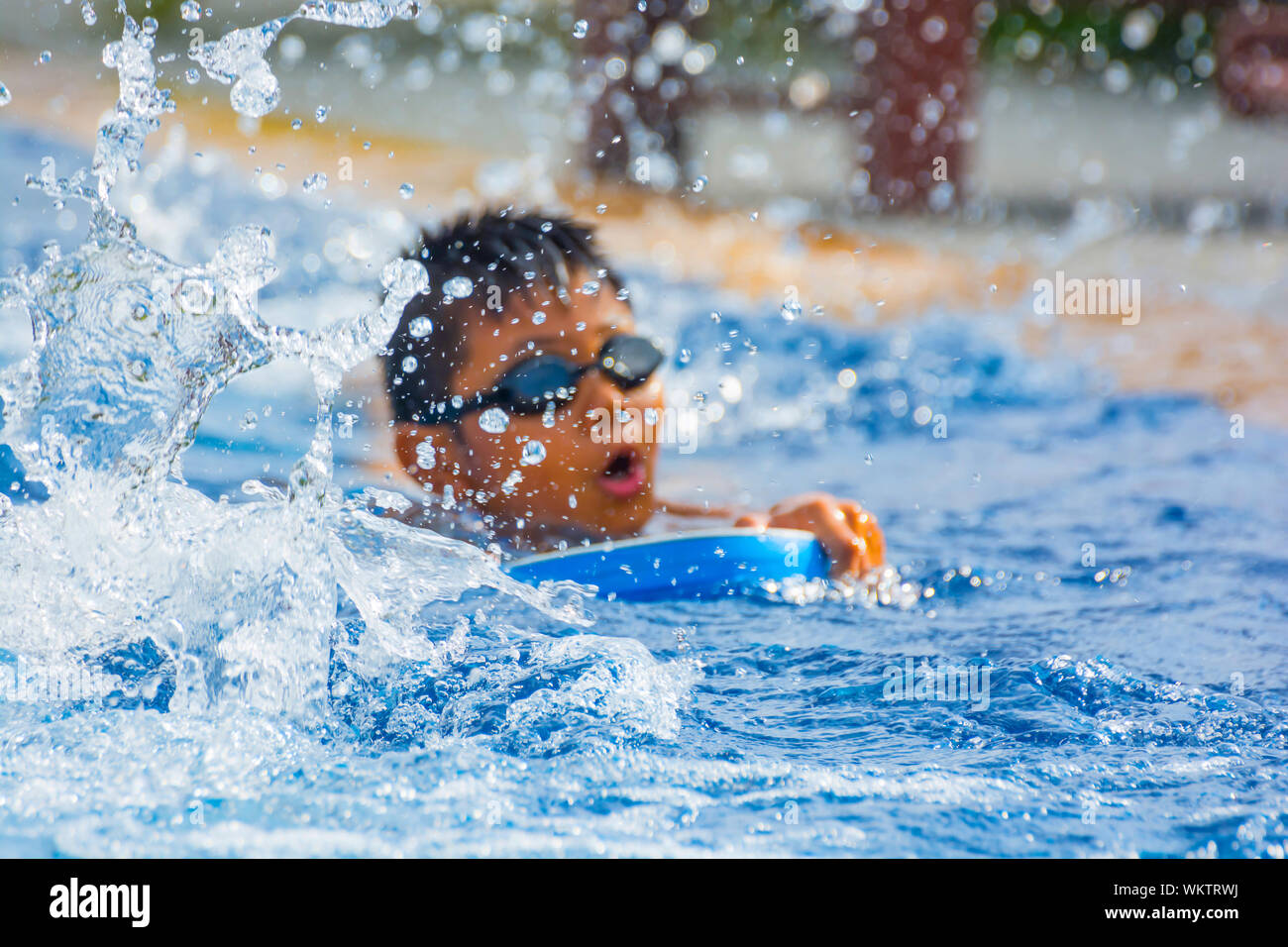 Boy splashing in swimming pool hi-res stock photography and images - Alamy