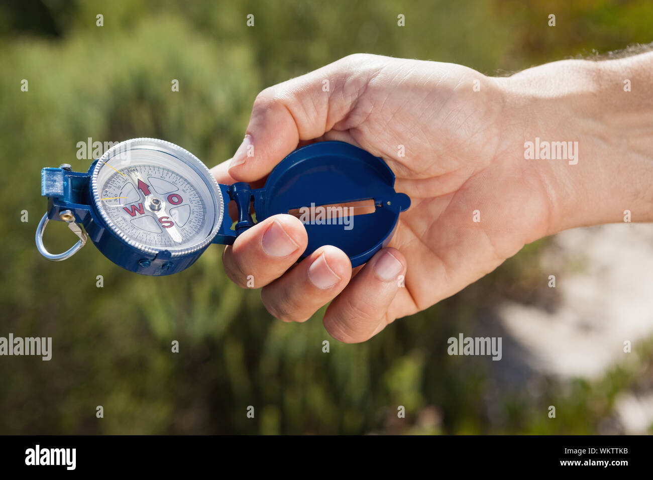 Hiker holding his compass in the countryside on a sunny day Stock Photo ...