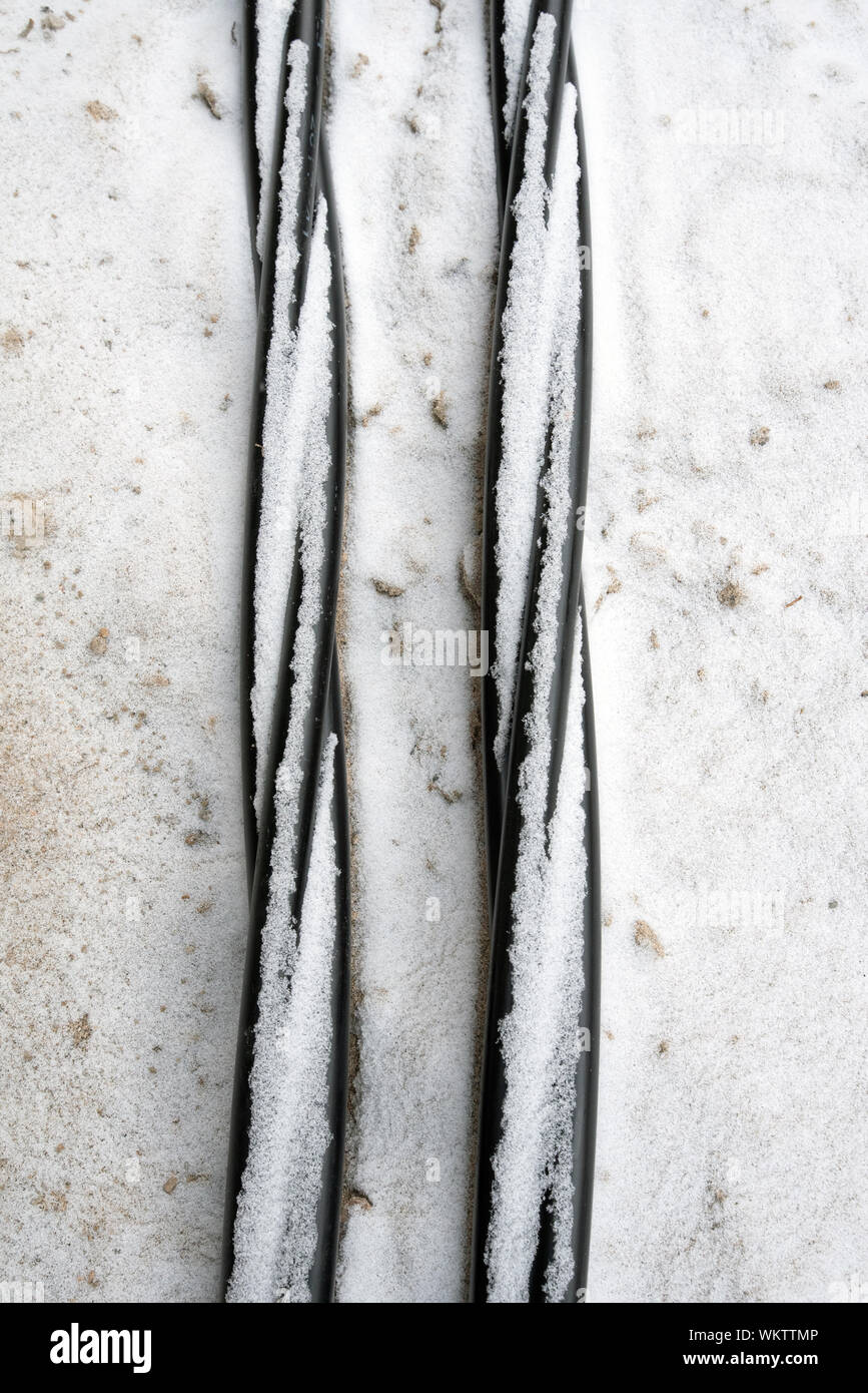 Laying a fiber optic and electricity cables in the frozen ground ...