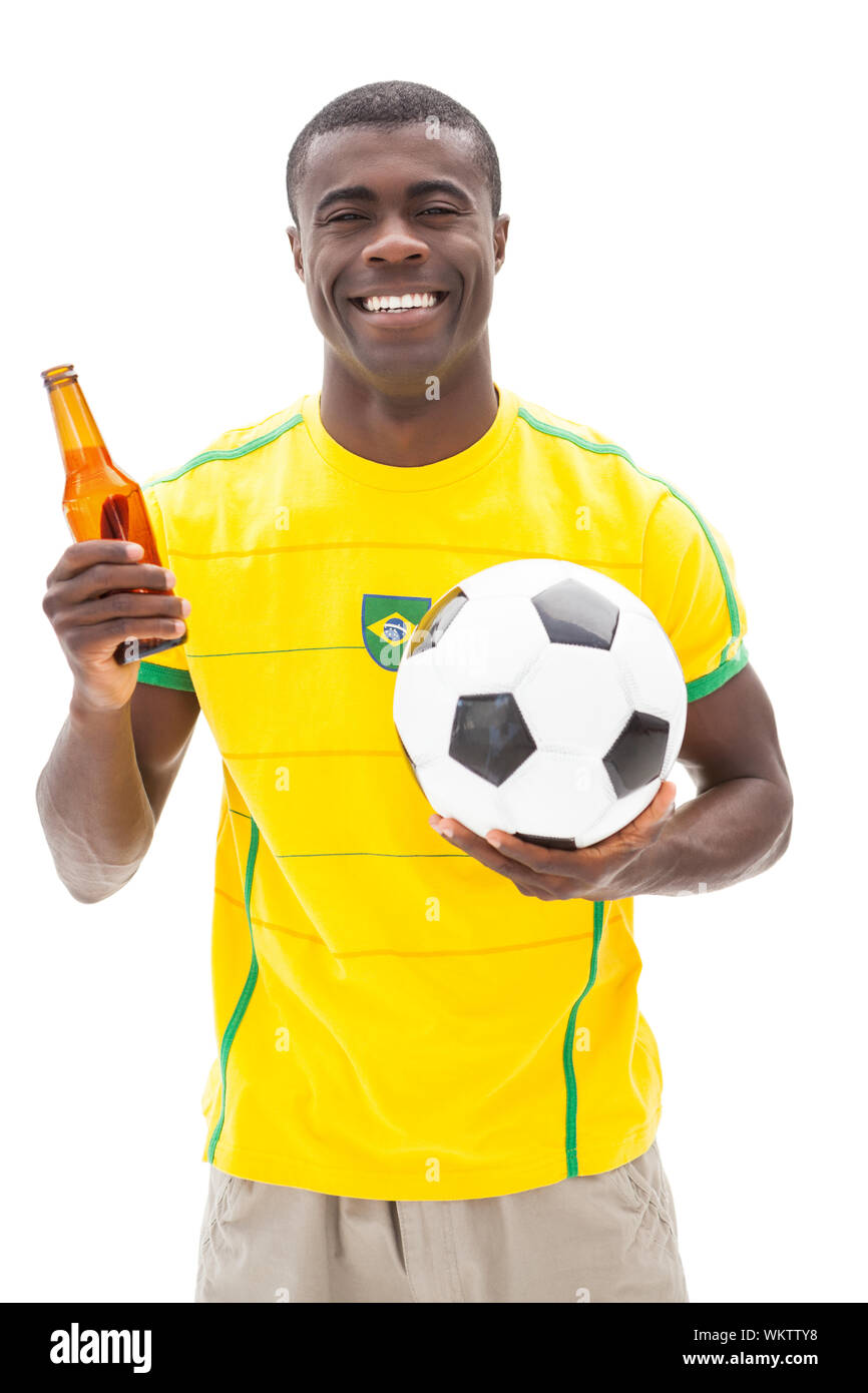 Happy brazilian football fan holding ball and beer on white background ...