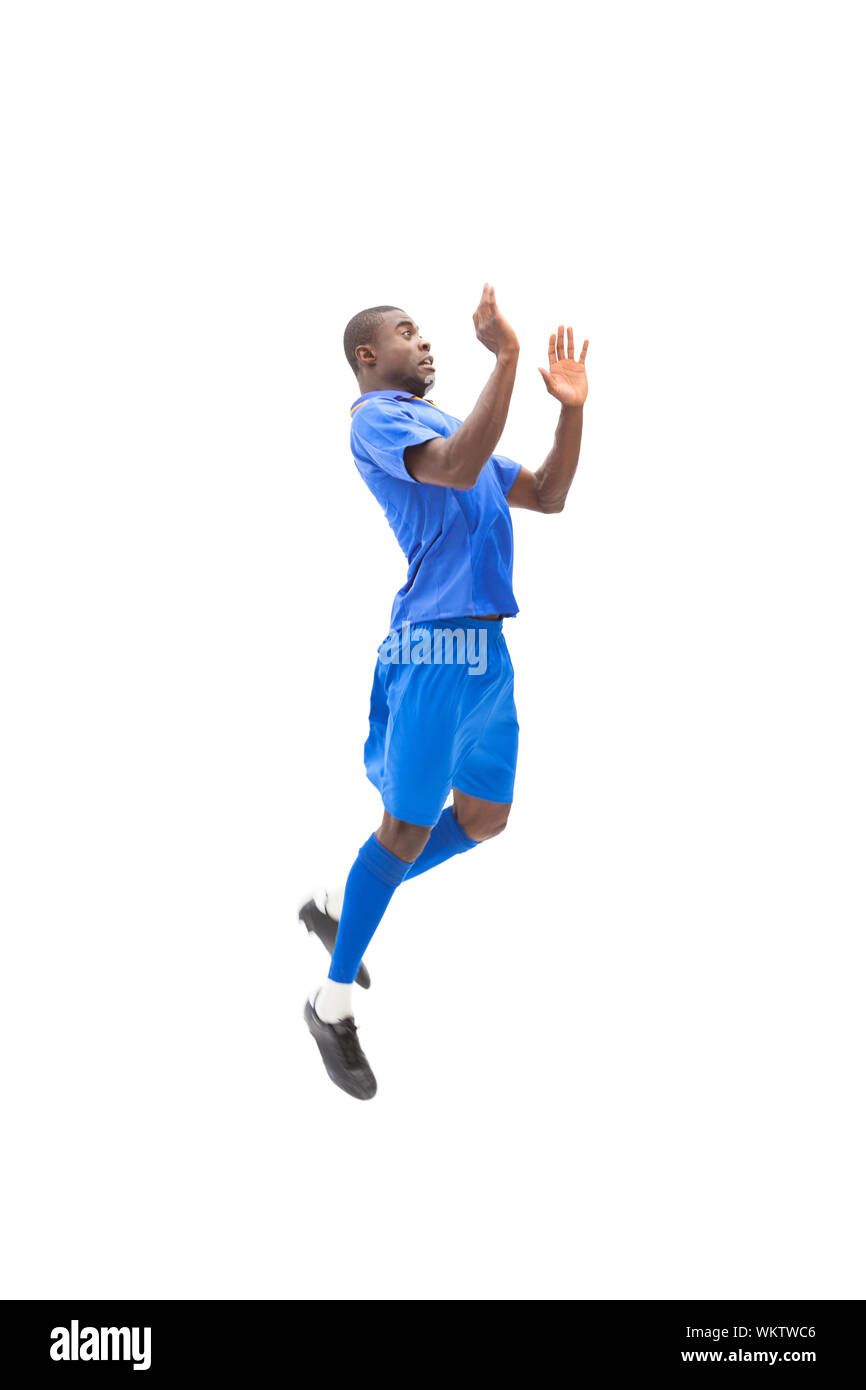 Football player in blue jumping on white background Stock Photo - Alamy