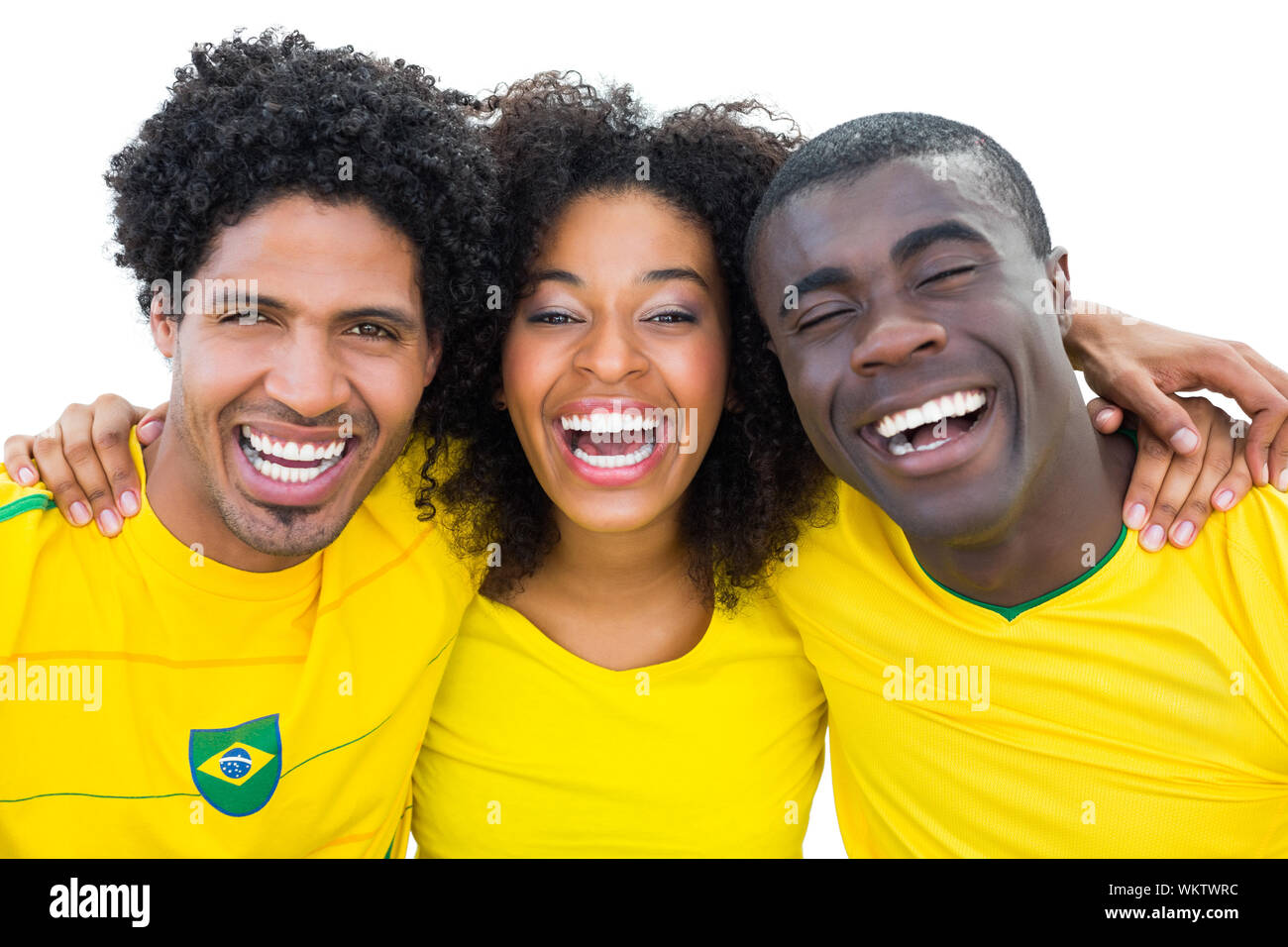Happy brazilian football fans in yellow smiling at camera on white ...