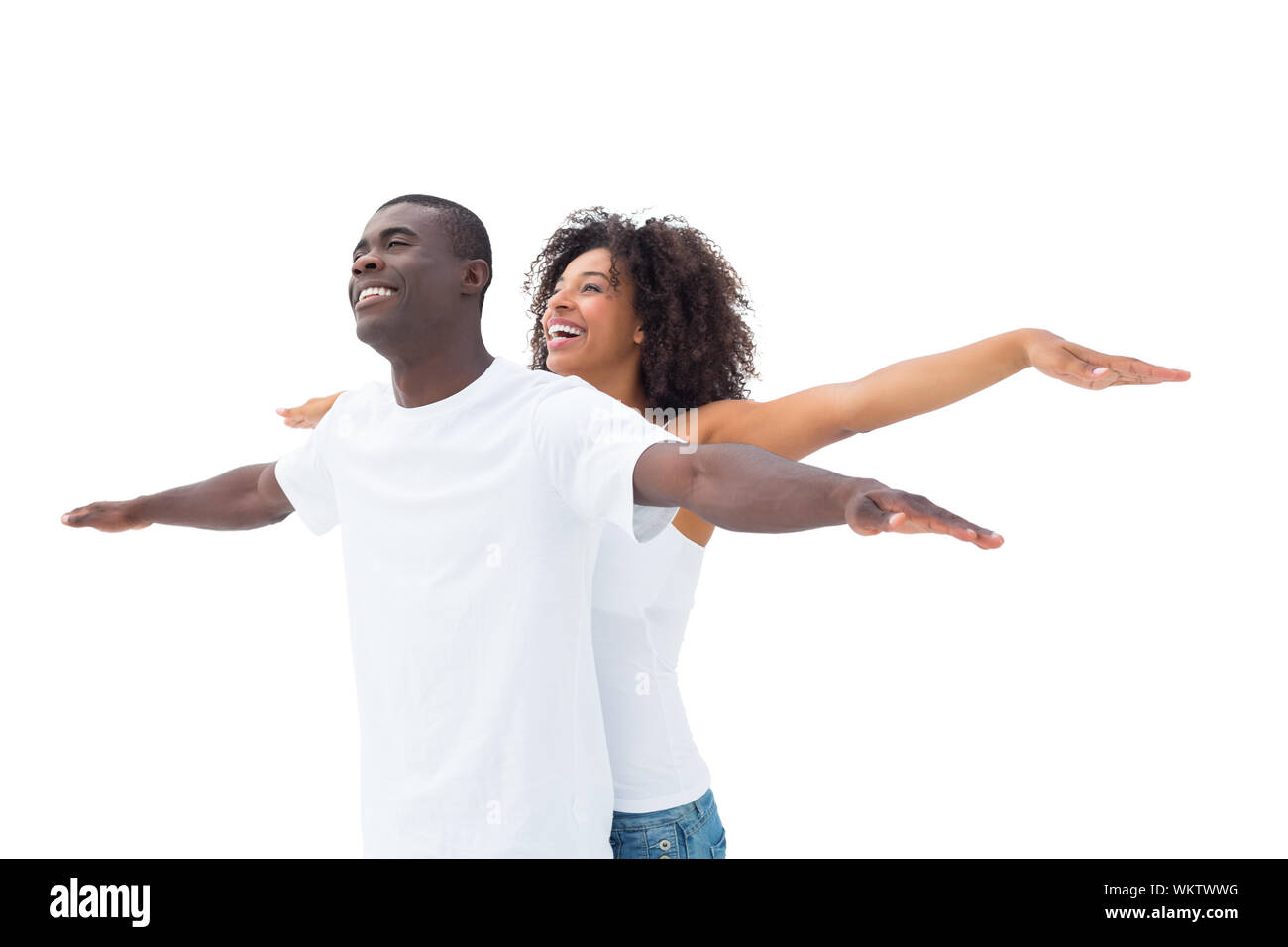 Casual couple standing with arms outstretched on white background Stock ...