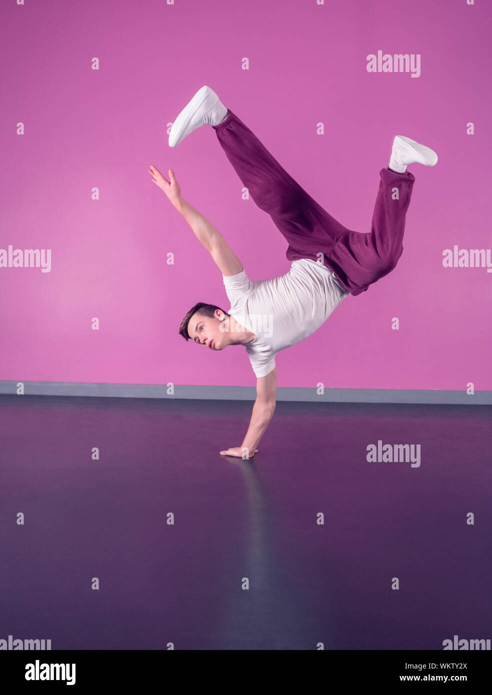 Cool break dancer doing handstand on one hand in the dance studio Stock ...
