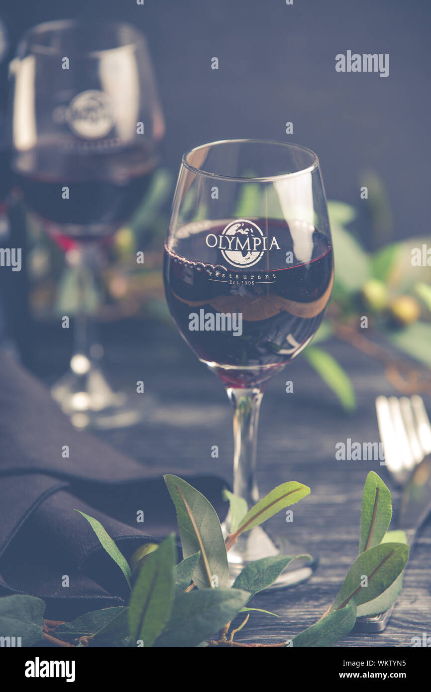 Glass of red wine with Olympia logo Stock Photo - Alamy