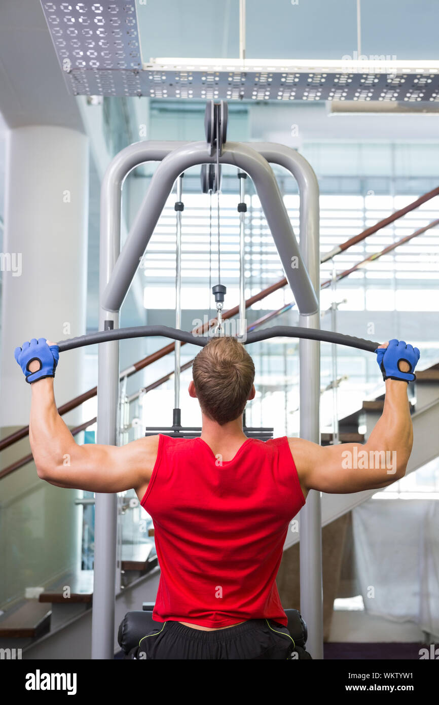Strong man using weights machine for arms at the gym Stock Photo - Alamy