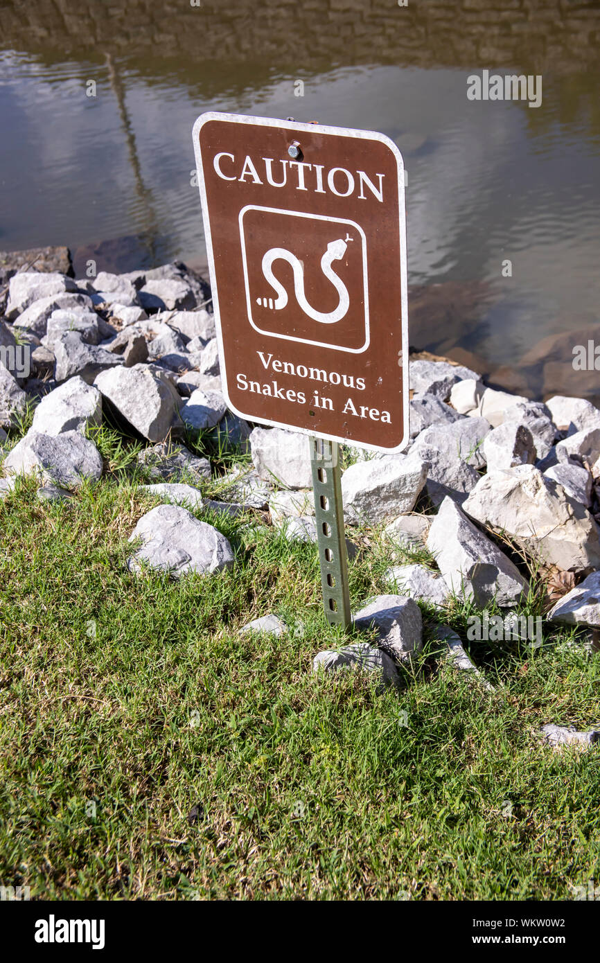 Illustrated sign warning of venomous snakes on side of creek Stock ...