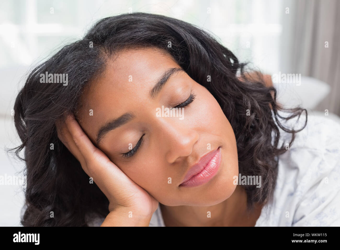 Pretty woman lying on bed with her eyes closed at home in bedroom Stock ...