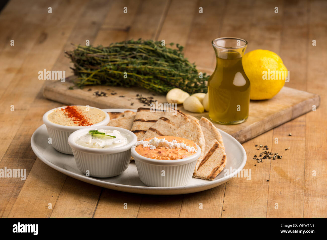 greek appetizers with olives and dips served on white plates with pita ...