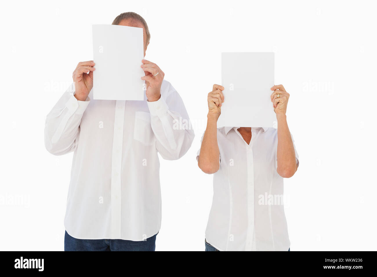Couple holding paper over their faces on white background Stock Photo ...