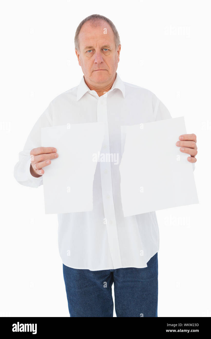 Serious man holding torn sheet of paper on white background Stock Photo ...