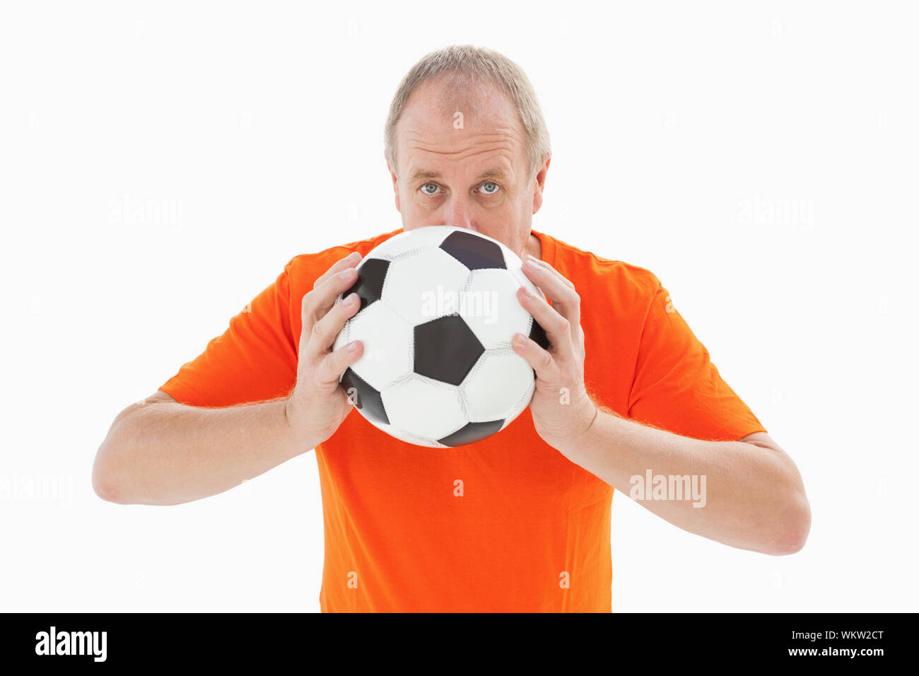 Nervous football fan holding ball on white background Stock Photo - Alamy