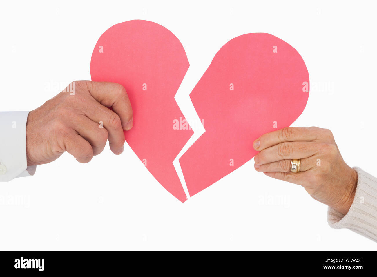 Couple holding a broken paper heart on white background Stock Photo - Alamy