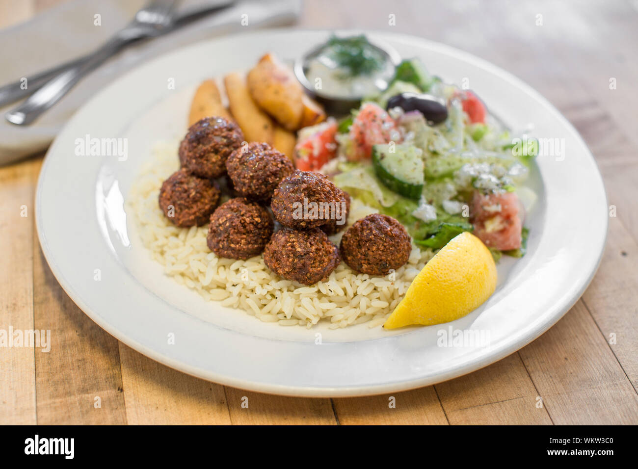 traditional Greek Dinner with rice, spices, salad on white dinner plate ...