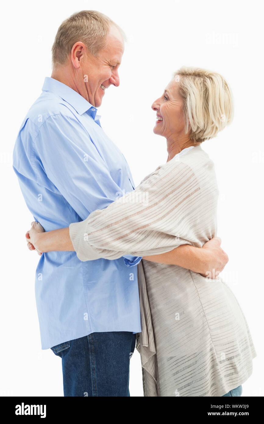 Happy mature couple hugging and smiling on white background Stock Photo ...