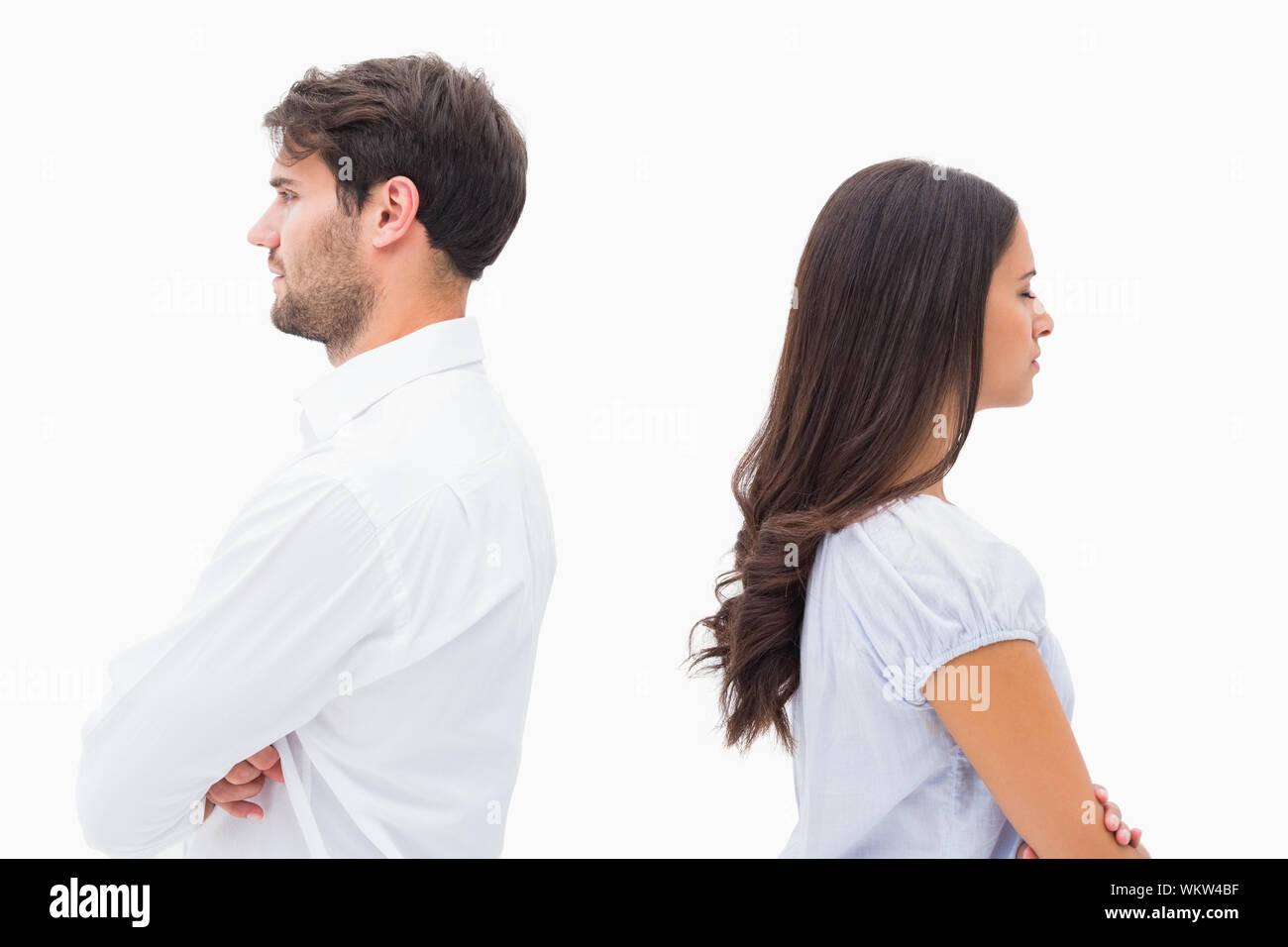 Upset couple not talking to each other after fight on white background ...