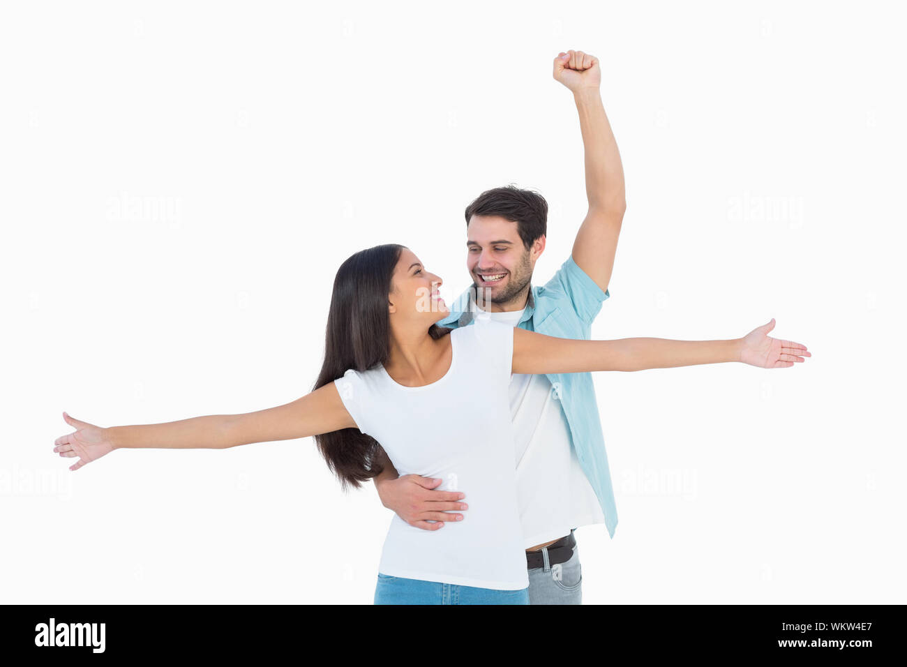 Happy casual couple cheering together on white background Stock Photo ...