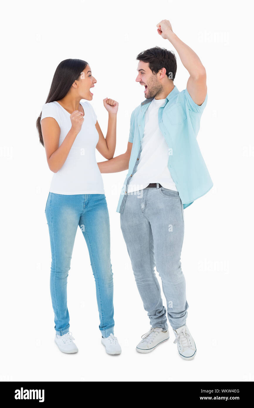 Happy casual couple cheering together on white background Stock Photo ...