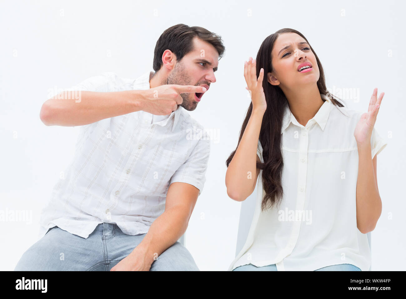 Couple sitting on chairs arguing on white background Stock Photo - Alamy