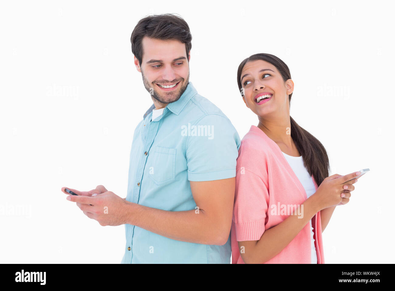 Happy couple sending text messages on white background Stock Photo - Alamy