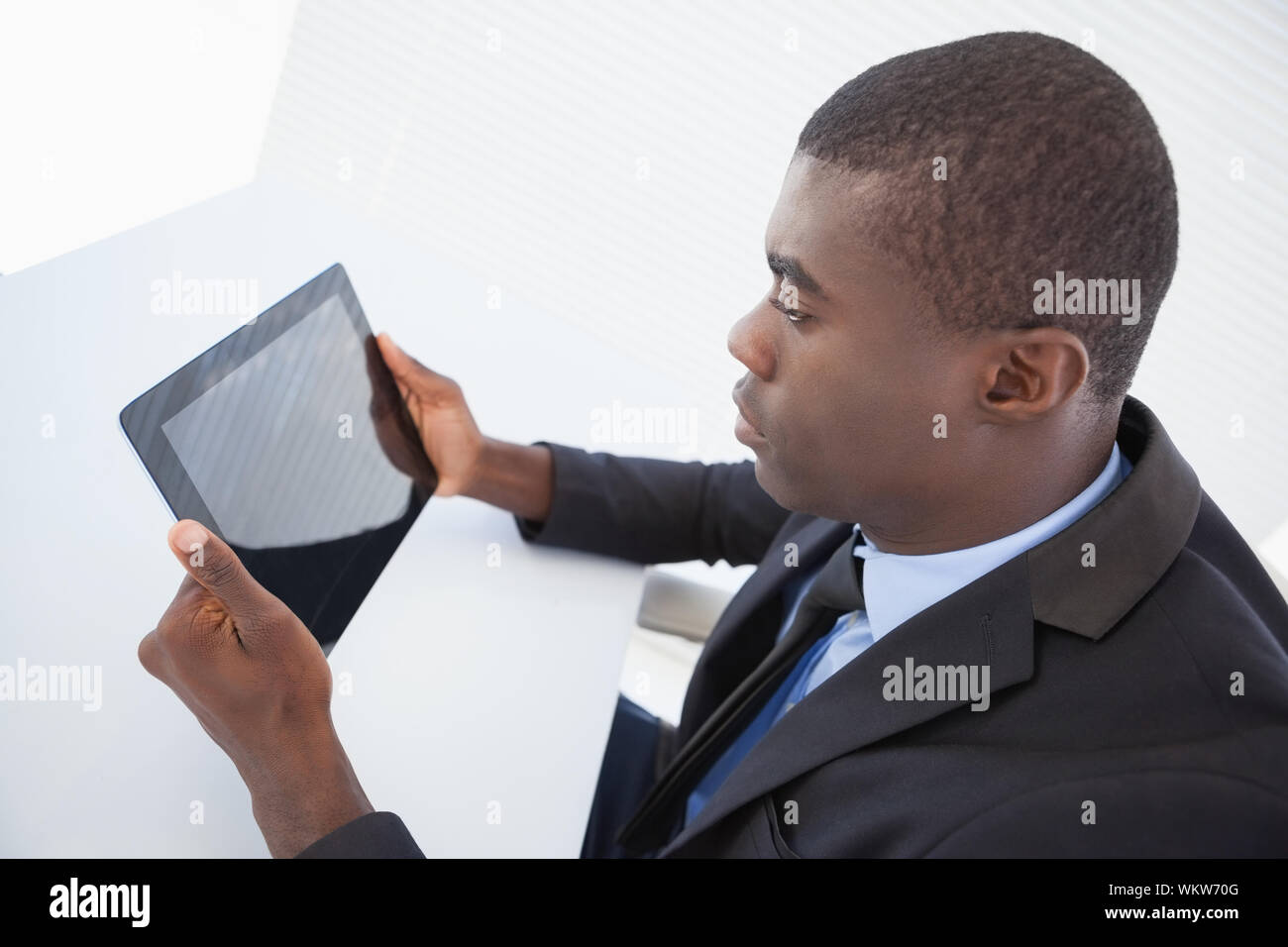 Focused businessman looking at his tablet in his office Stock Photo - Alamy