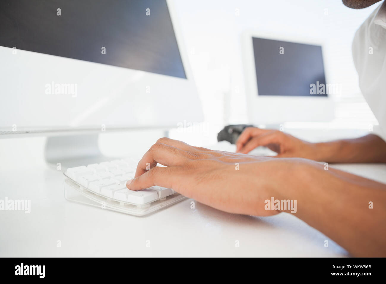 Business typing on keyboard at desk in his office Stock Photo - Alamy